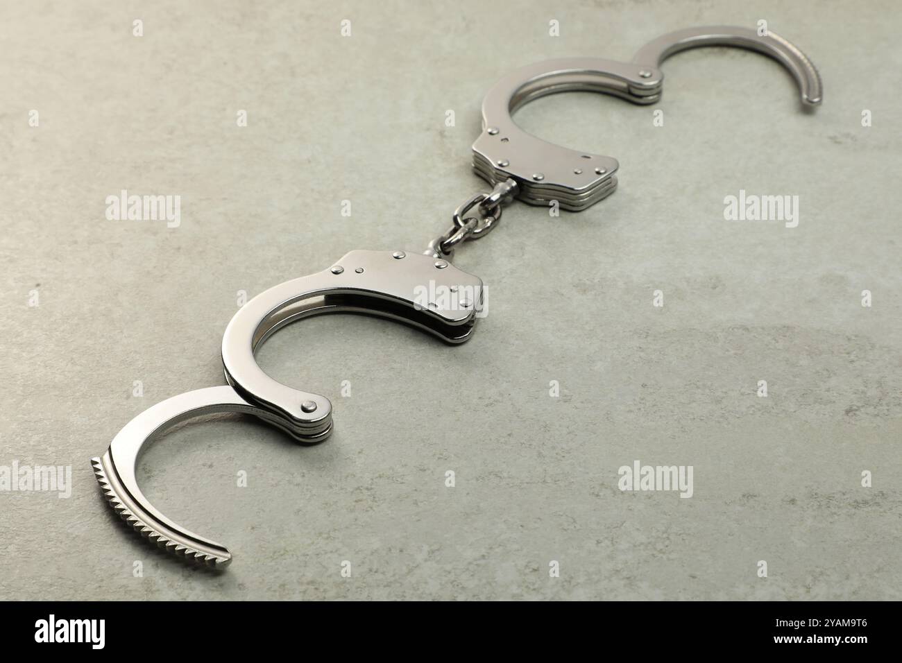Classic chain handcuffs on grey table, closeup Stock Photo - Alamy