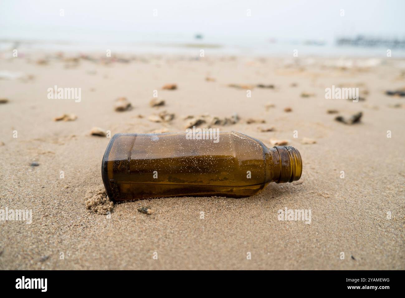 Empty glass bottles washed up on the beach Stock Photo - Alamy