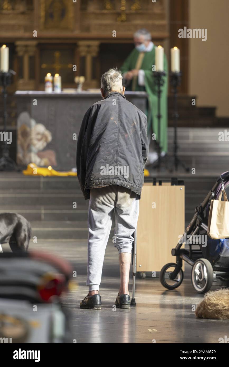 A mentally confused homeless man in the church, family mass with ...