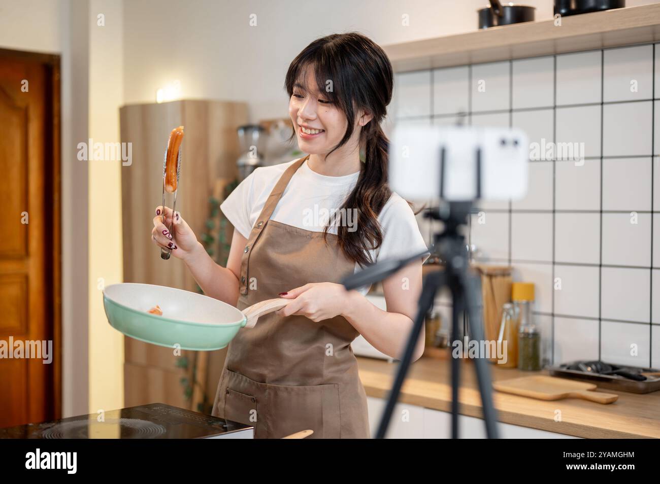 A pretty and happy young Asian female food content creator or chef in ...