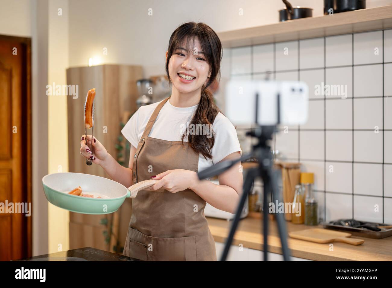 A pretty and happy young Asian female food content creator or chef in ...