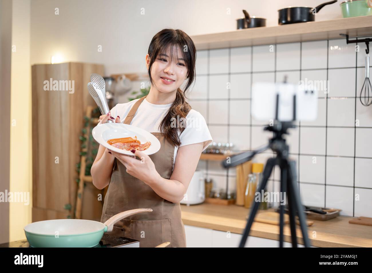 A pretty and happy young Asian female food content creator or chef in ...