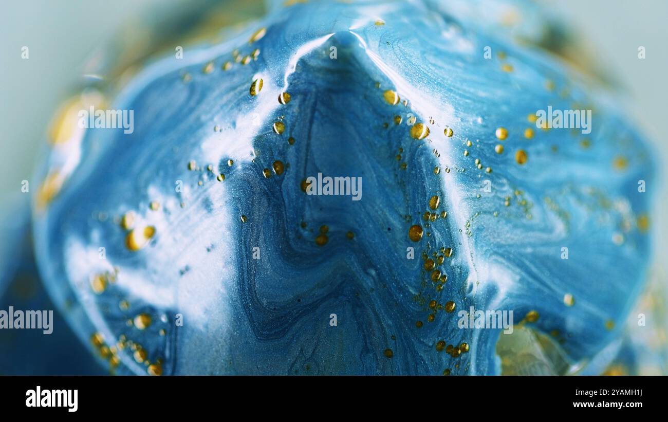 Ink pyramid. Sparkling paint drop. Defocused blue golden yellow color ...
