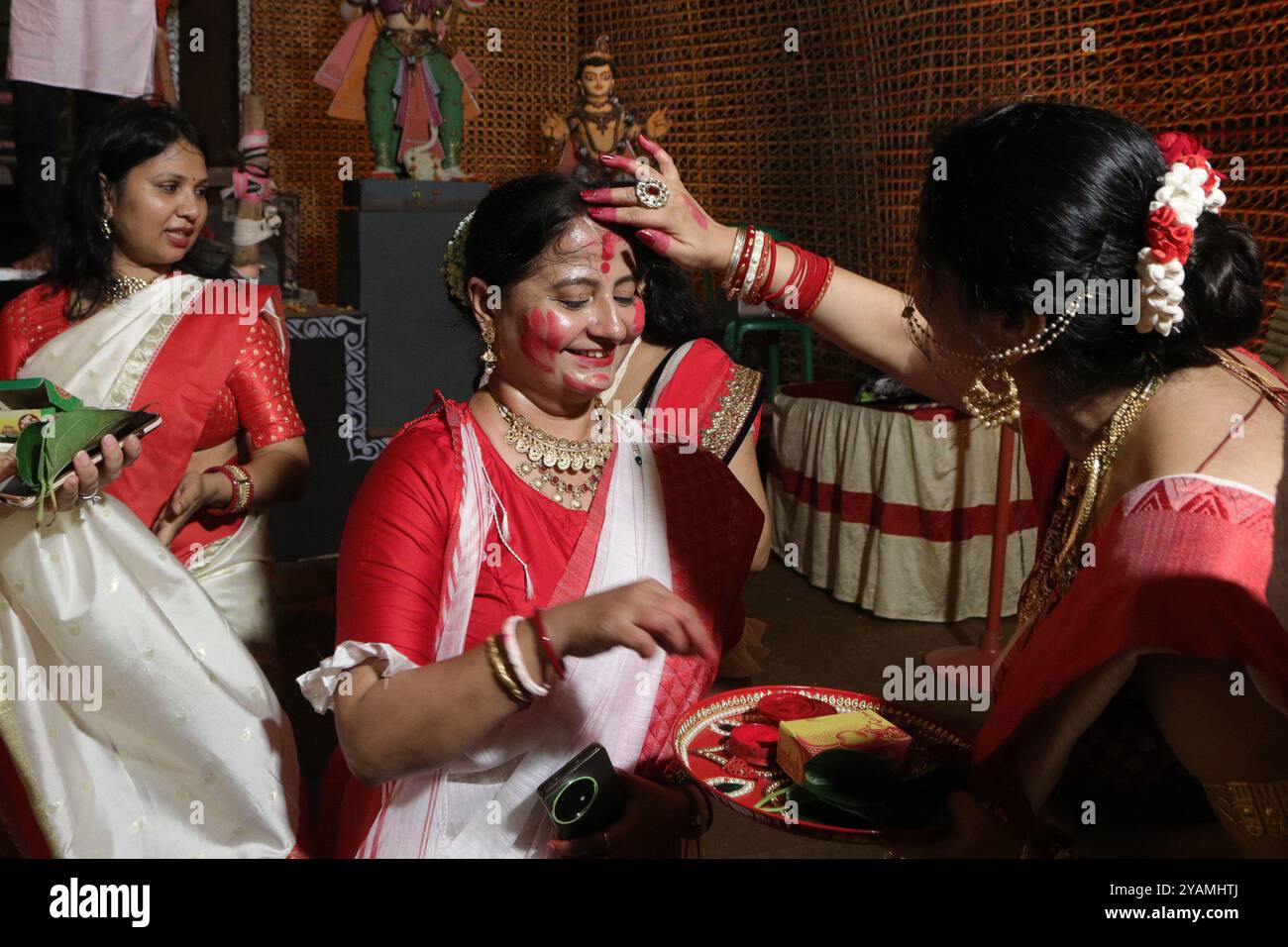 Non Exclusive: A Hindu woman smudges vermillion, a red powder, on ...