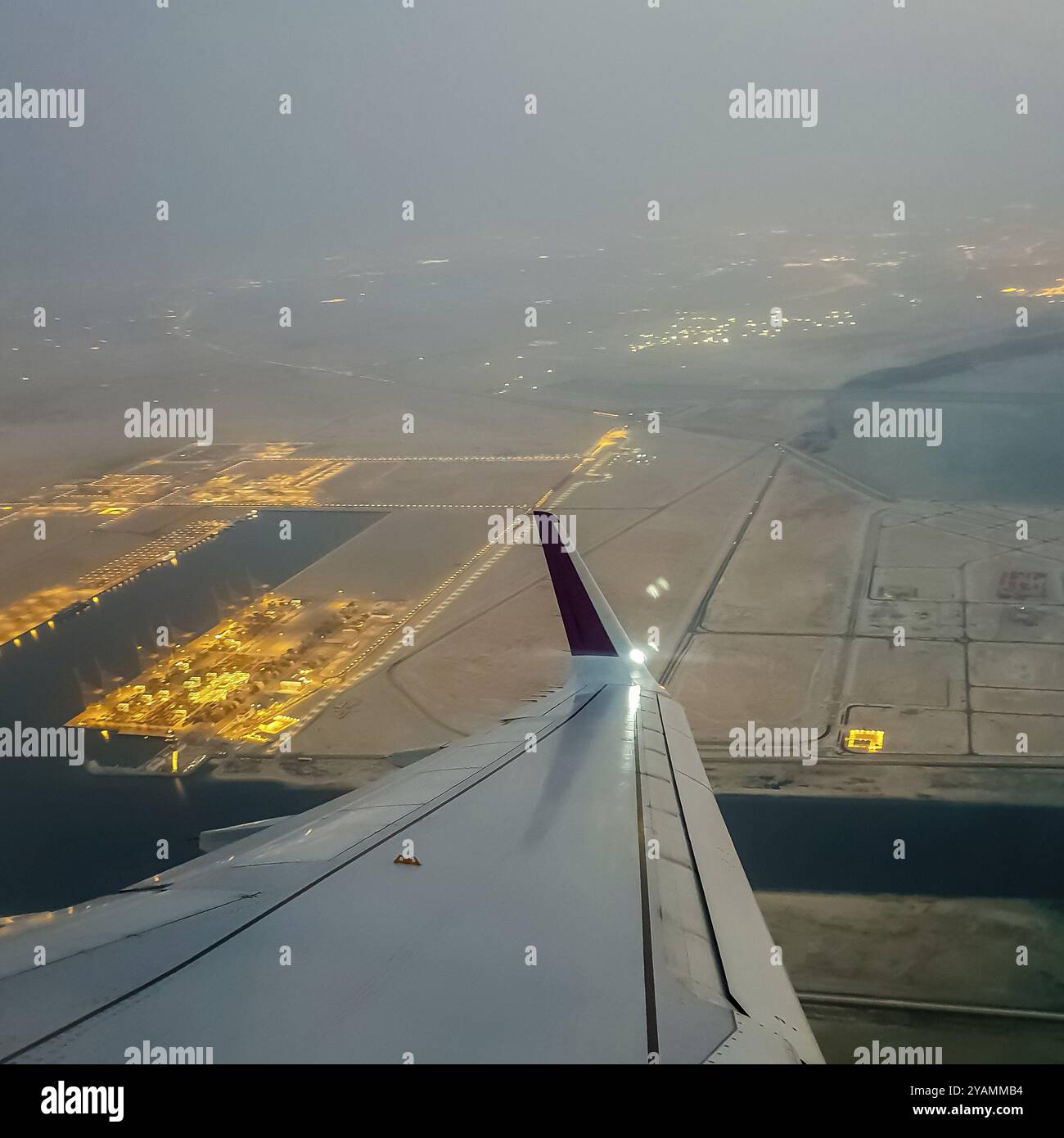Sunrise view above Doha Airport viewed inflight on a passenger airplane ...