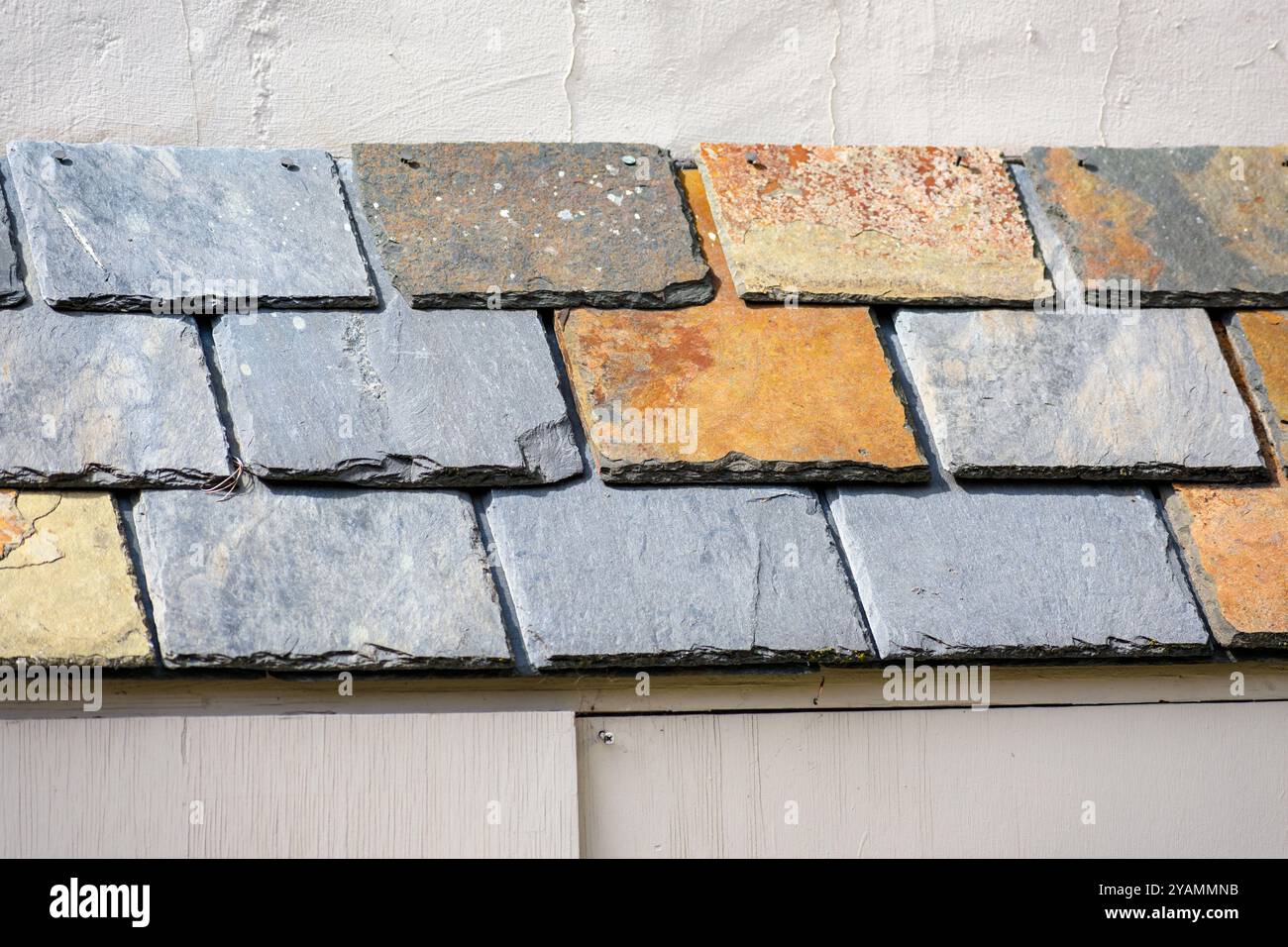 Detailed view of a rustic slate shingle roof with various earth-toned ...