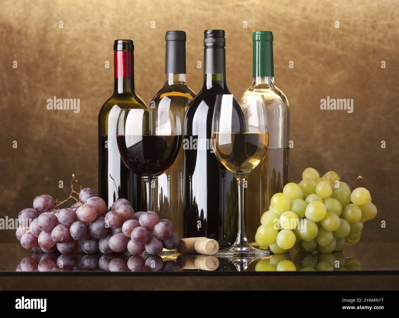 Several bottles of white and red wine, two glasses and grapes on a ...