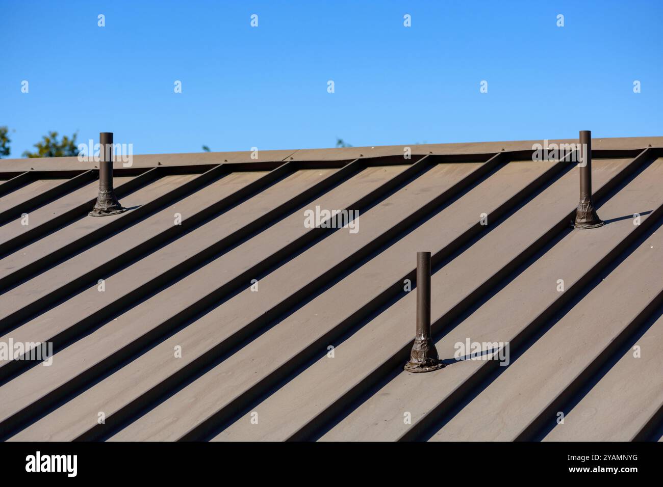 Three rooftop vent pipes installed on a sloped metal roof Stock Photo ...