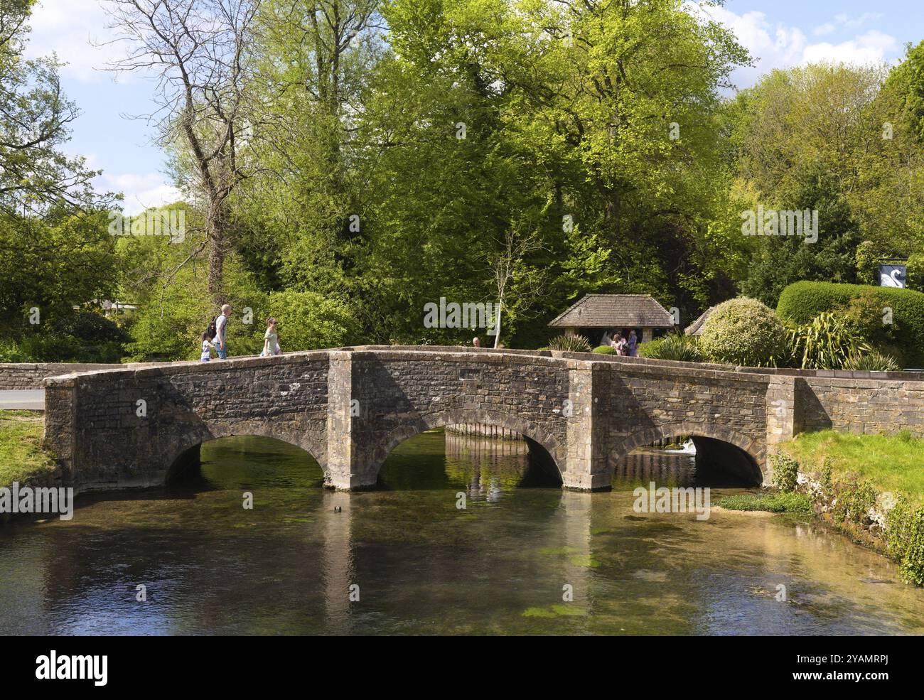 The old bridge at the trout farm over the River Coln in Bibury in the ...