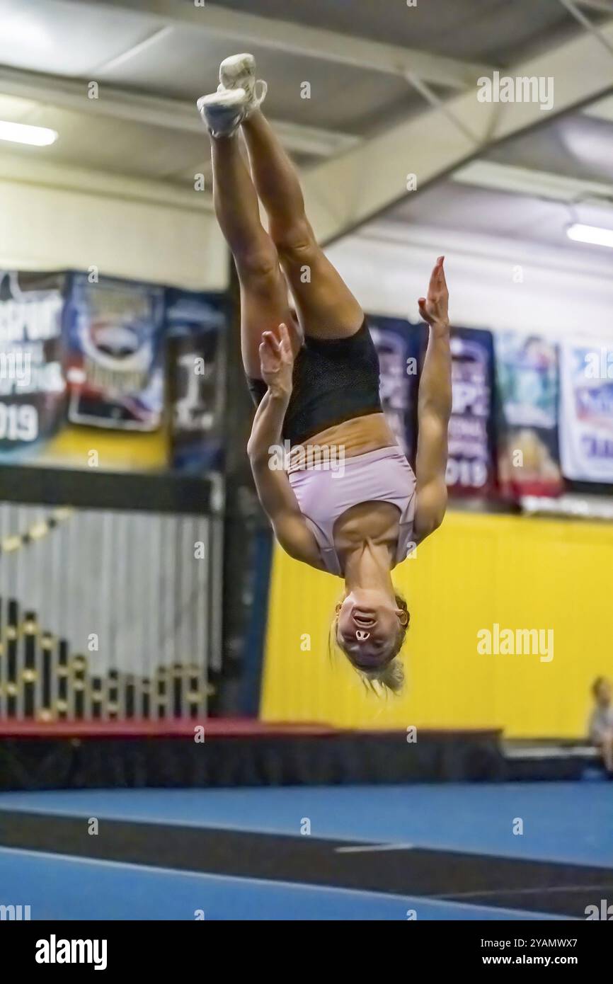 A toned gymnast perfects her routines at the gym ahead of a competition ...