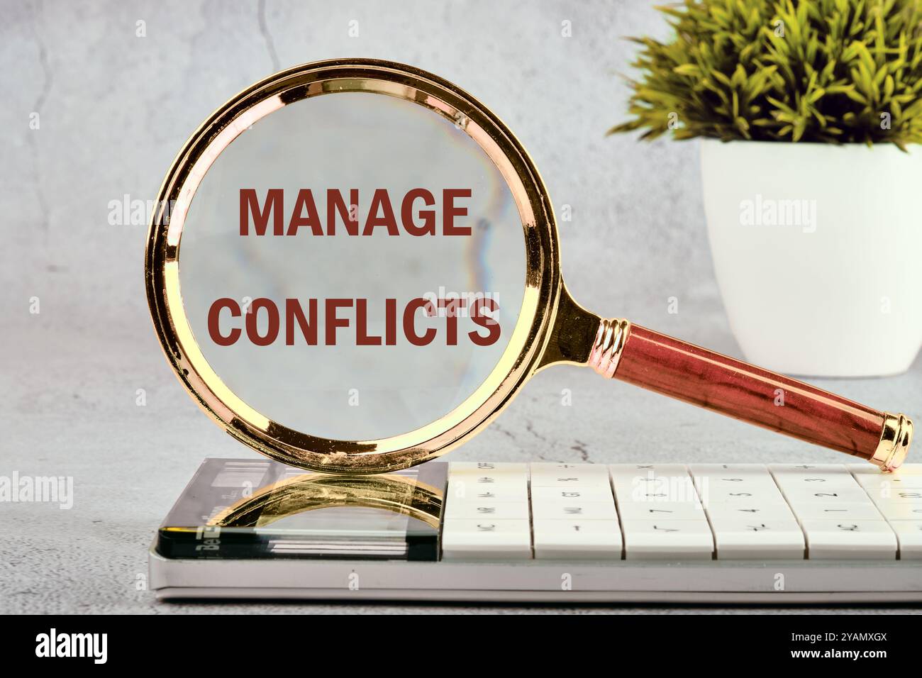 MANAGE CONFLICTS words through a magnifying glass on the wall, close-up ...