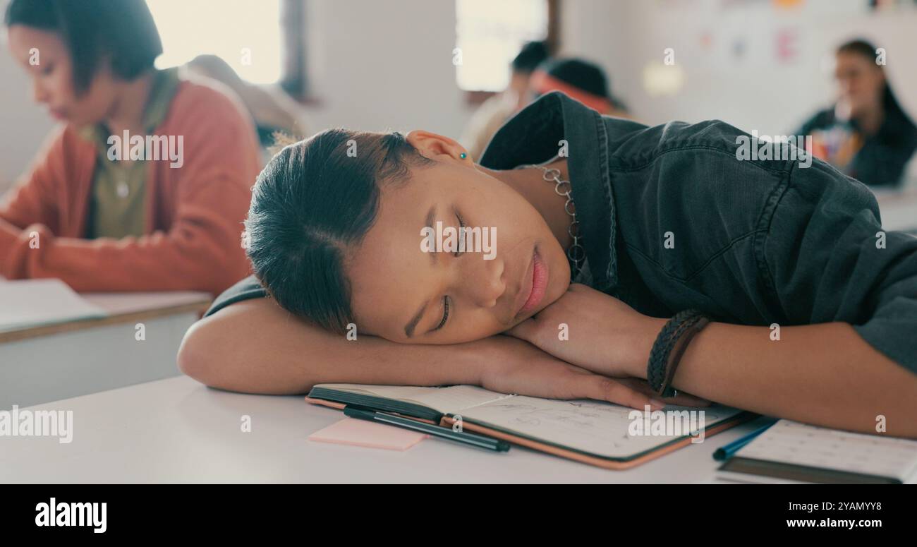 Exhausted, sleeping and student on desk in classroom at school with ...
