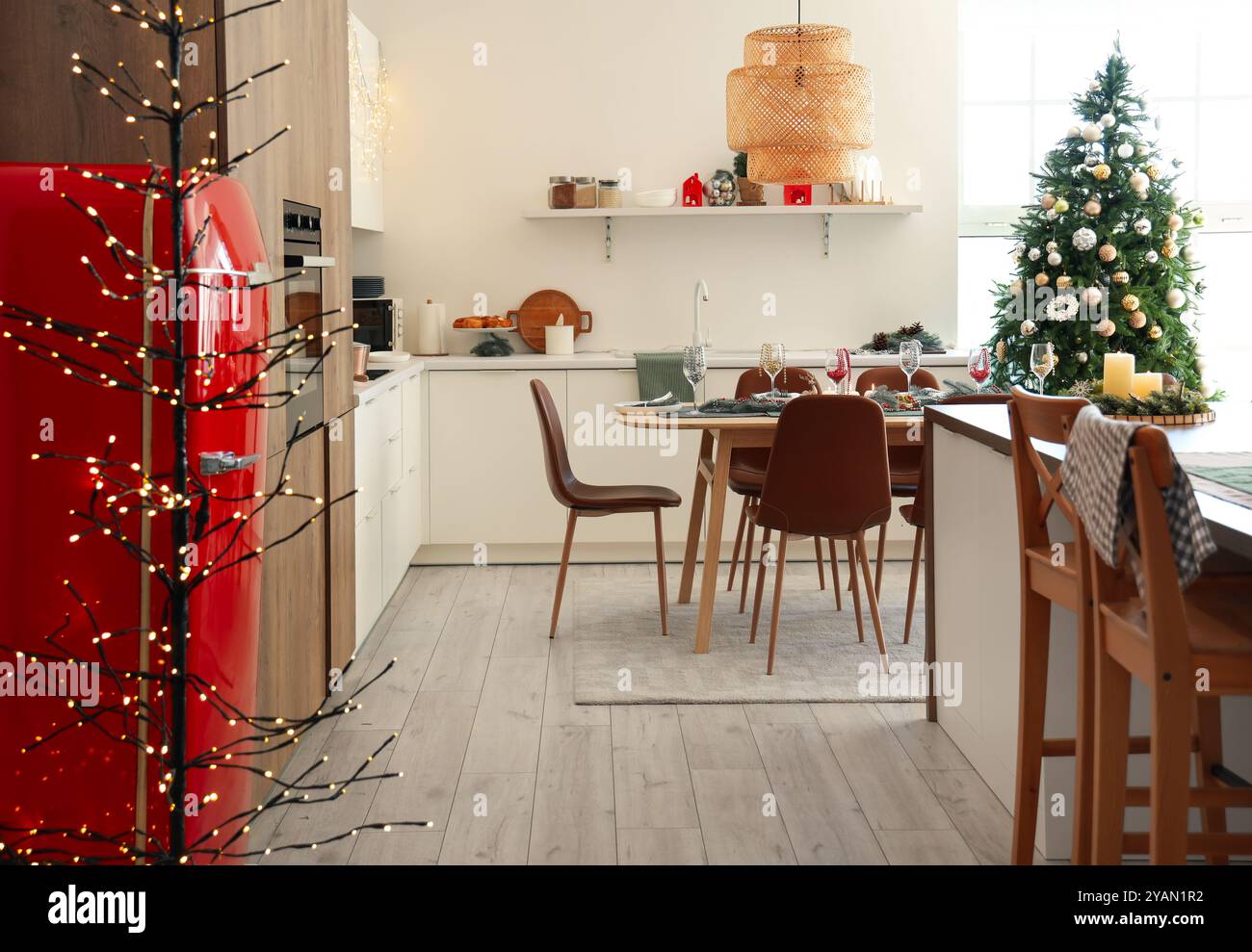 Interior of festive kitchen with Christmas tree and served dining table ...