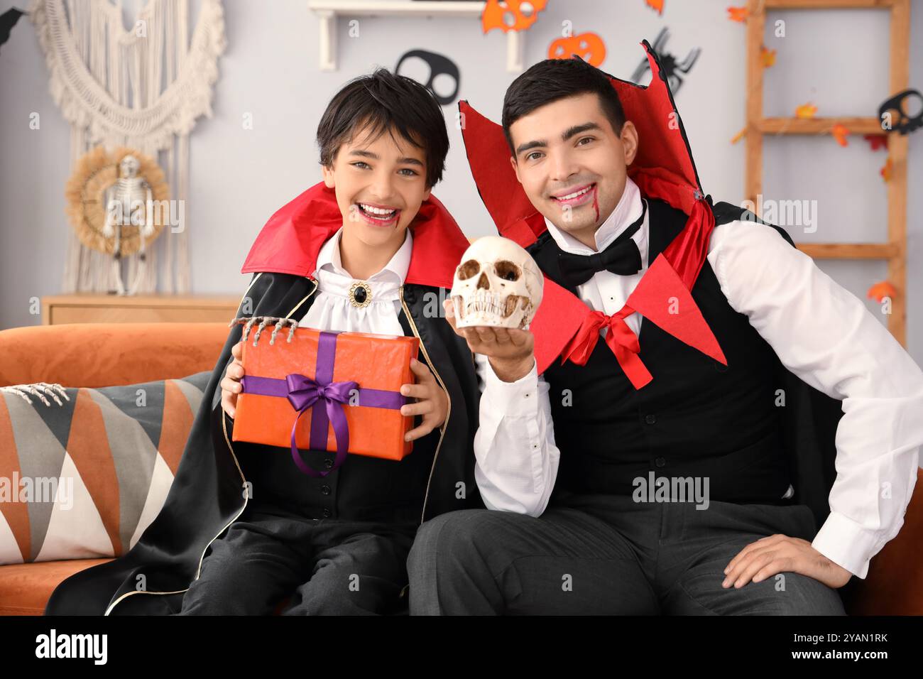 Little boy and his father dressed for Halloween as vampires with gift ...