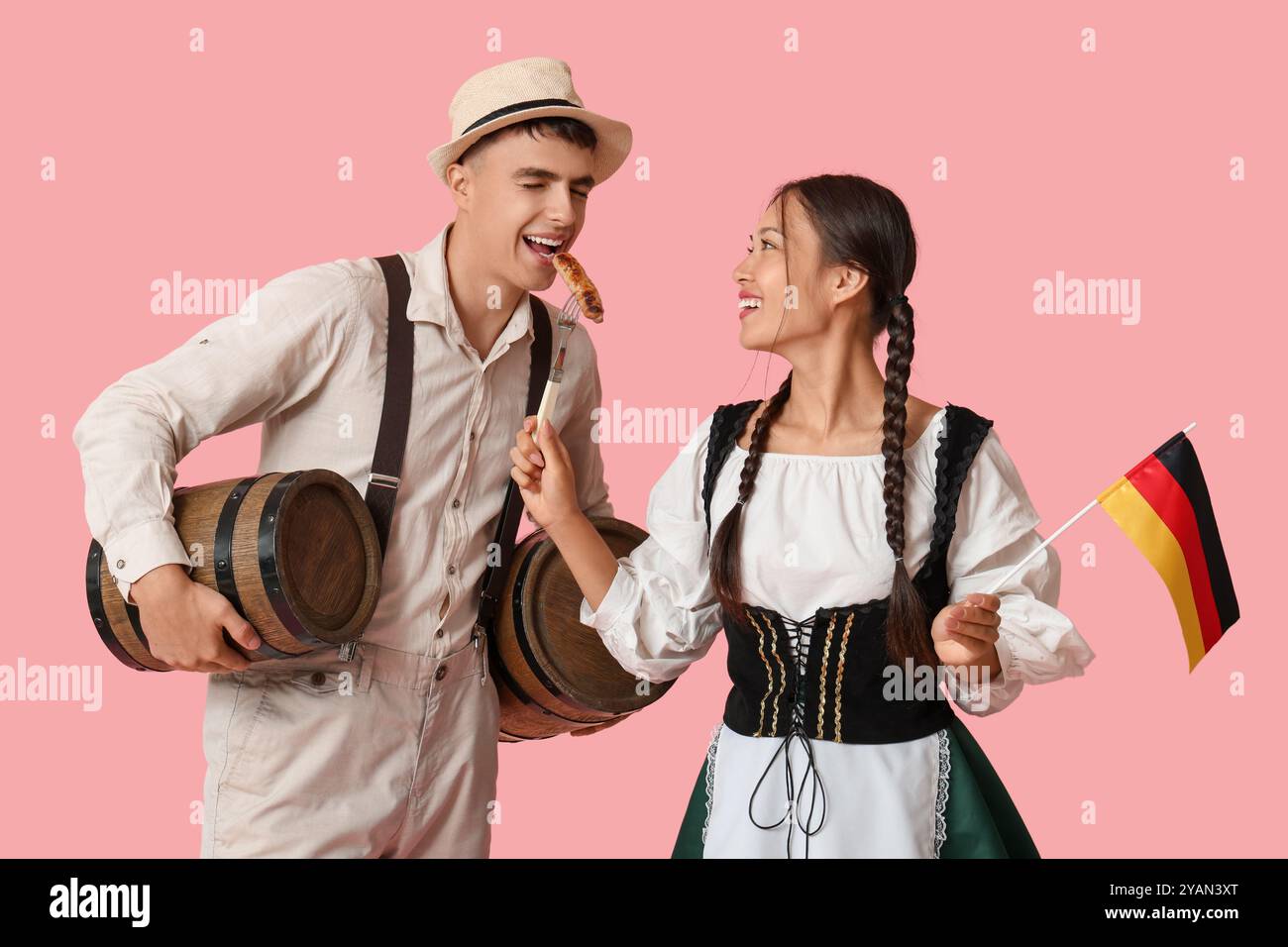 Young couple in traditional German clothes with barrels of beer ...