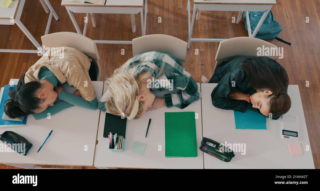 Tired, sleeping and group of students on desk in classroom at school ...