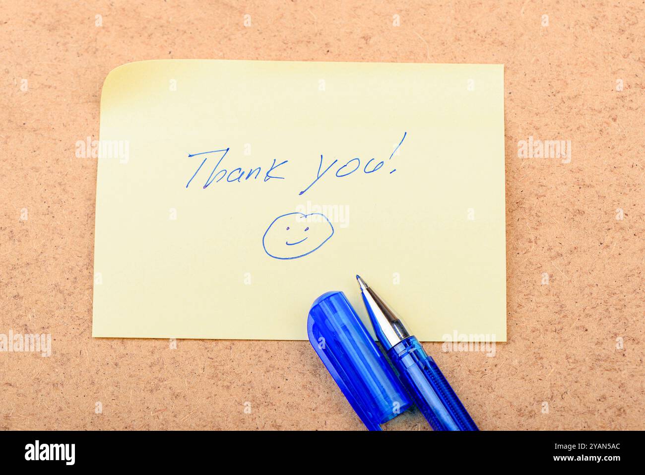 A handwritten note saying Thank you with a smiley face, placed on a ...