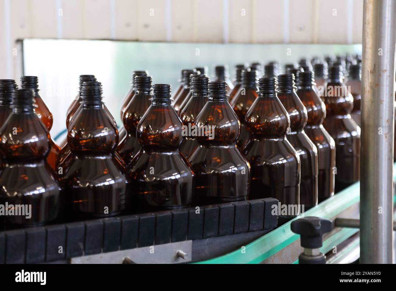 Empty plastic bottles moving on a conveyor line at a beverage and beer ...