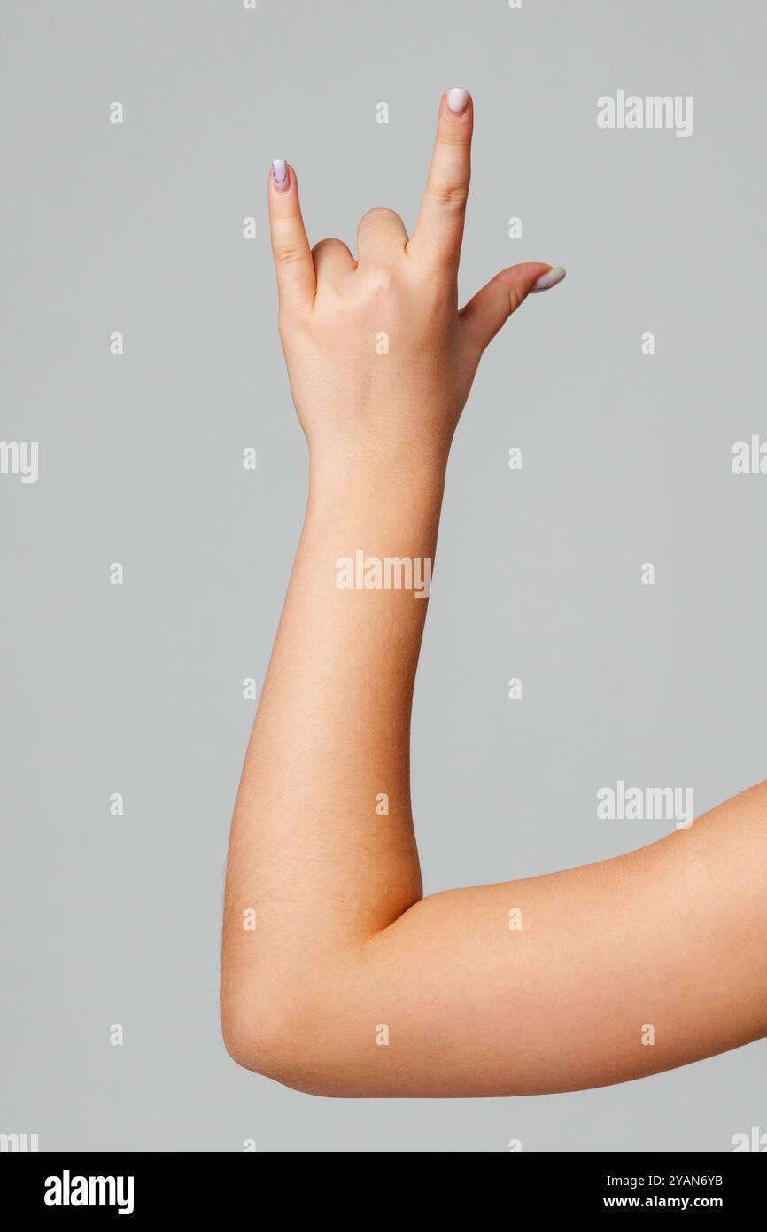 Hand gesture expressing love or appreciation in a neutral setting with ...