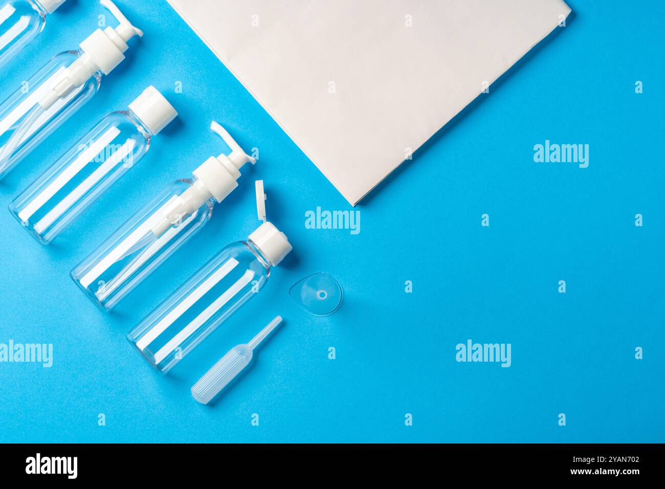 Various clear plastic bottles and containers arranged on a blue ...