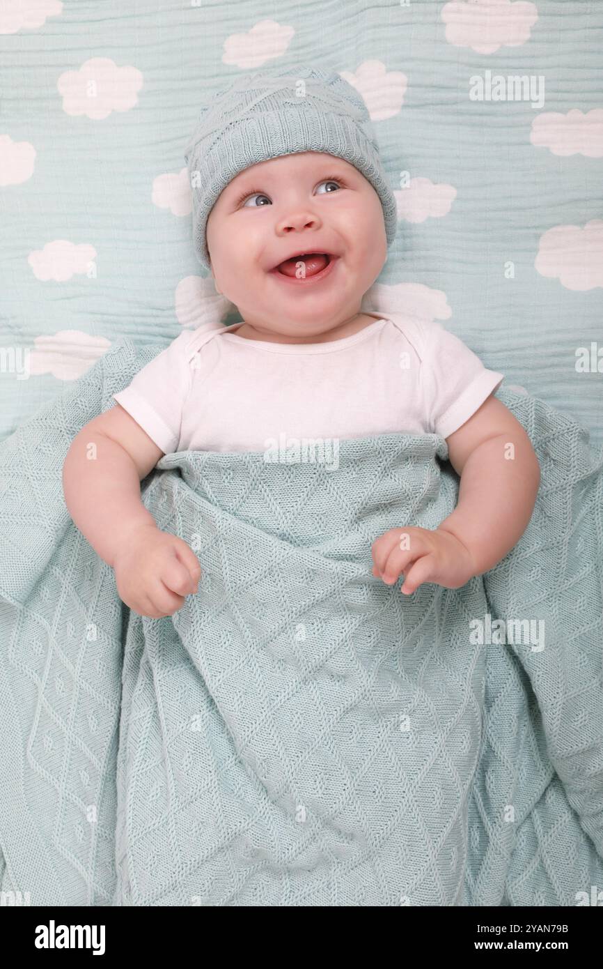 Sweet little baby girl (six months old) lying in bed covered with a blanket, top view Stock ...