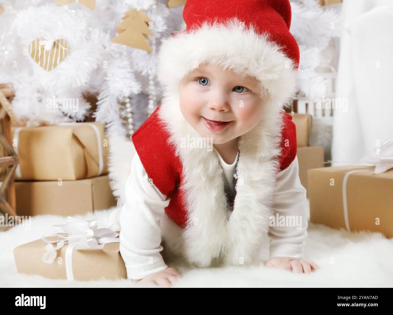 Little girl (eight months of age) dressed as Santa sitting under a ...