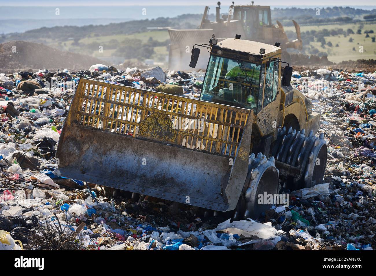 Heavy machinery shredding garbage in an open air landfill. Waste Stock ...