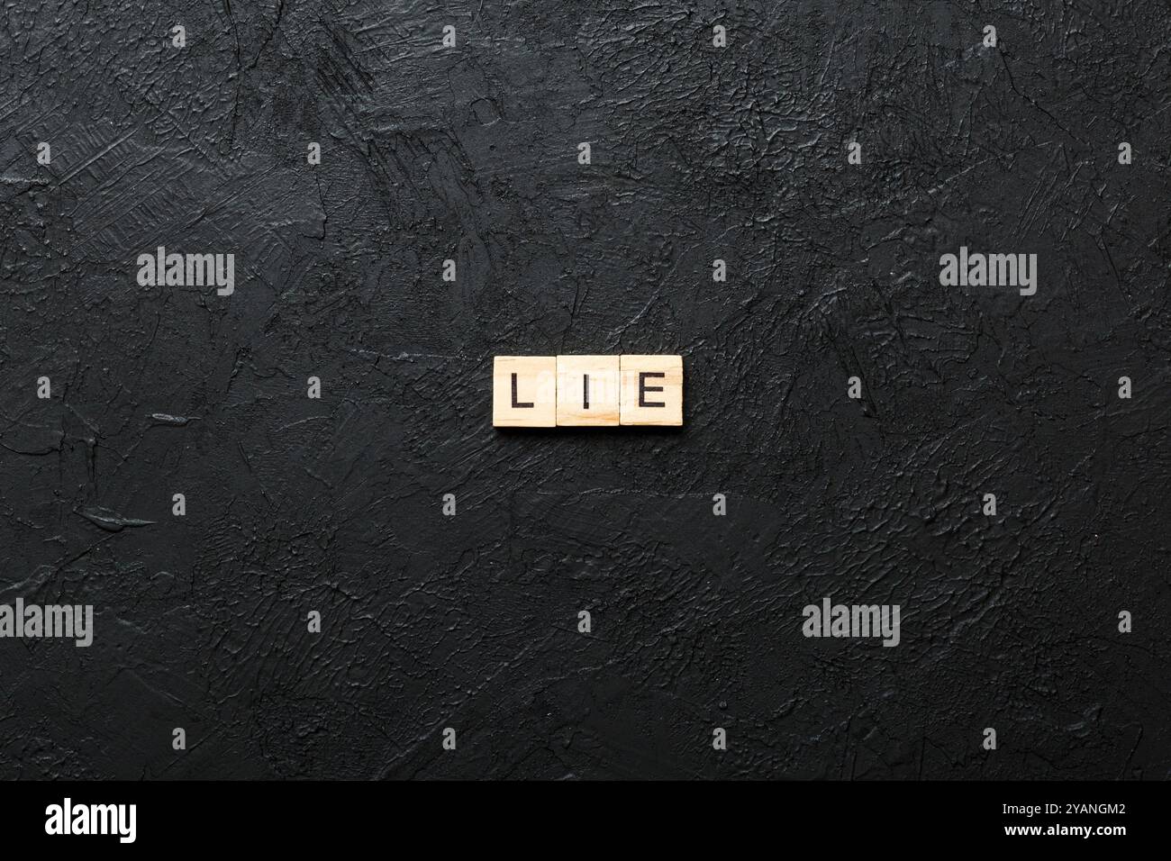 LIE word written on wood block. LIE text on cement table for your ...