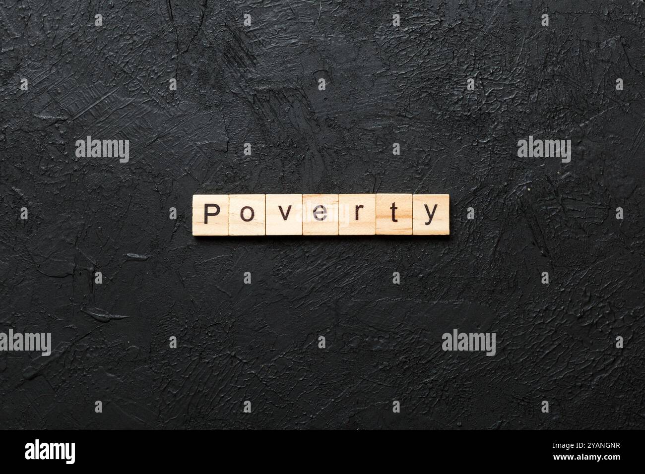 Poverty word written on wood block. Poverty text on cement table for ...