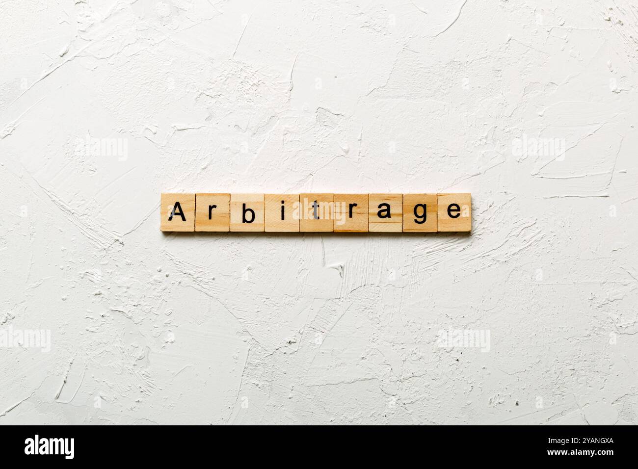Arbitrage word written on wood block. Arbitrage text on cement table ...