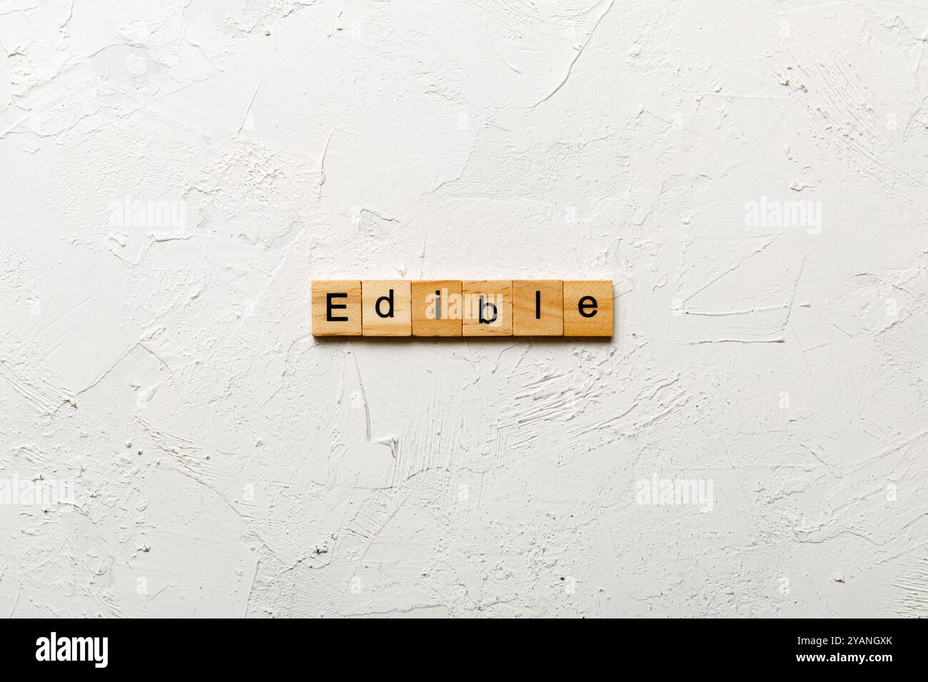 EDIBLE word written on wood block. EDIBLE text on cement table for your ...