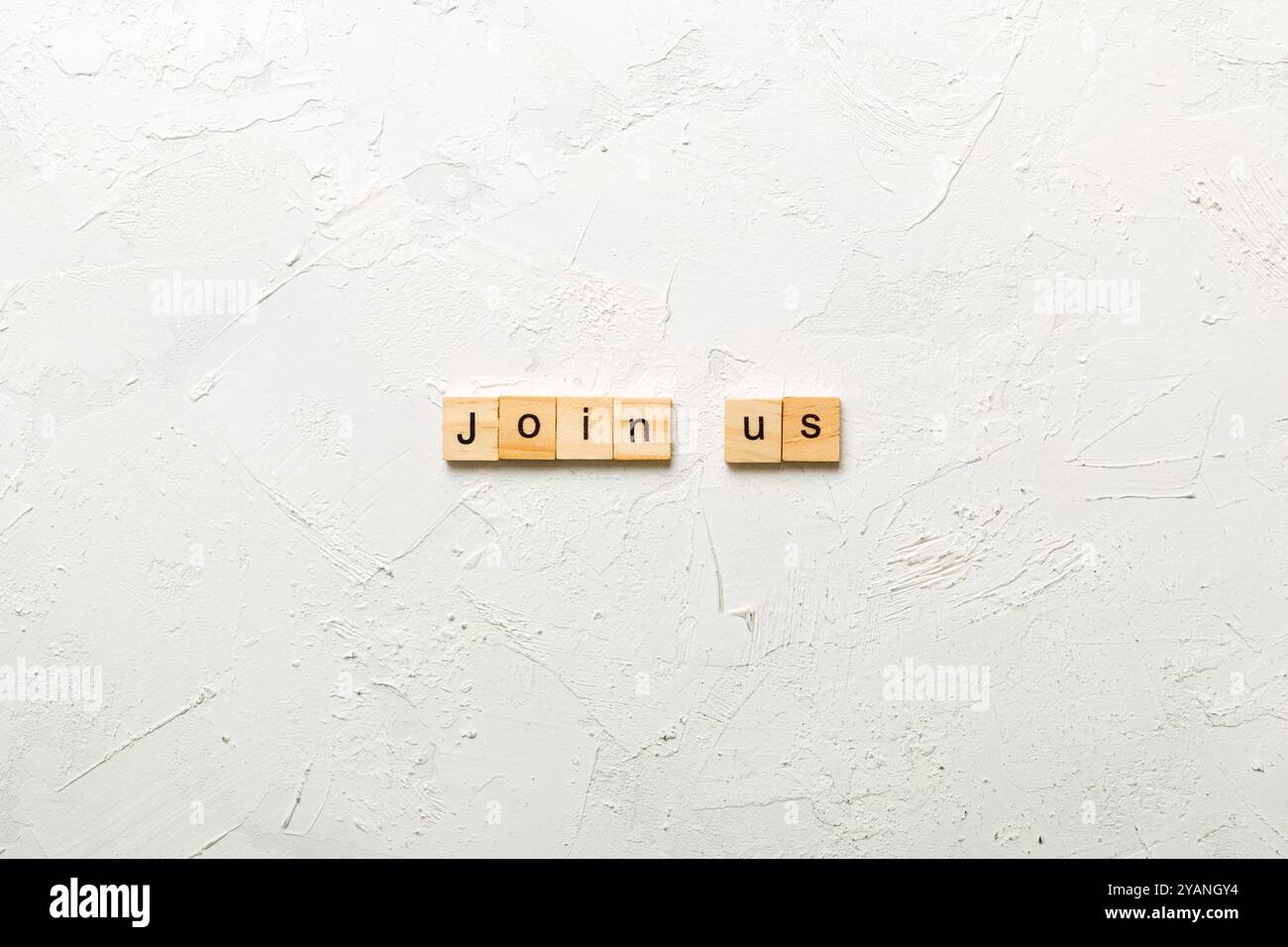Join us word written on wood block. Join us text on cement table for ...