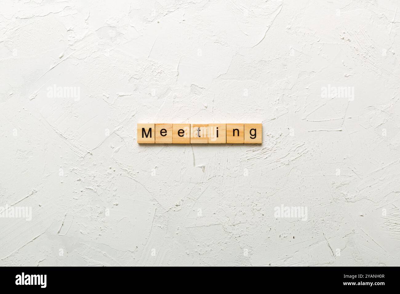 MEETING word written on wood block. MEETING text on cement table for ...