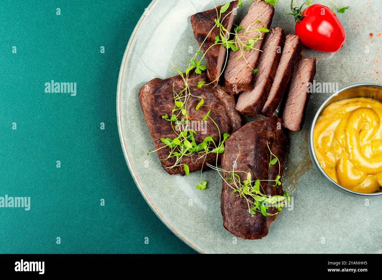 Roasted ostrich meat steaks with sauce. African cuisine. Copy space ...