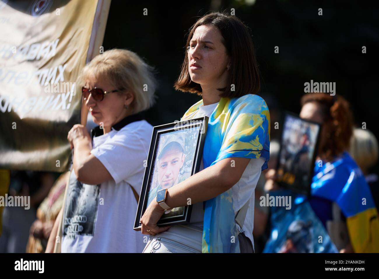 Sad Ukrainian woman walks with a portrait of her husband, soldier of ...