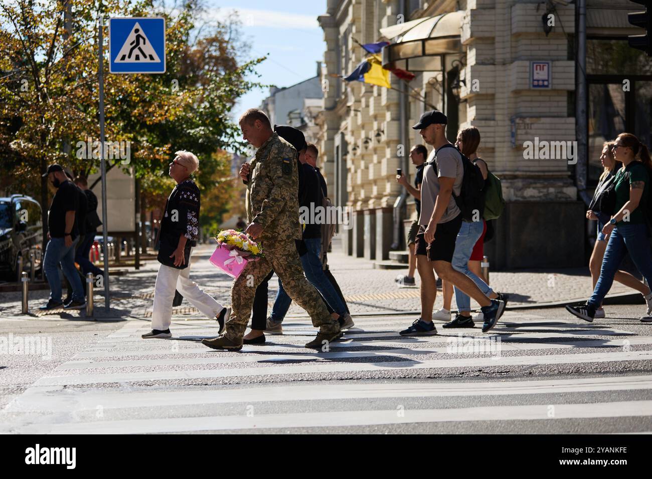 Ukrainian soldiers walks with bouquet of flowers with the crowd of ...