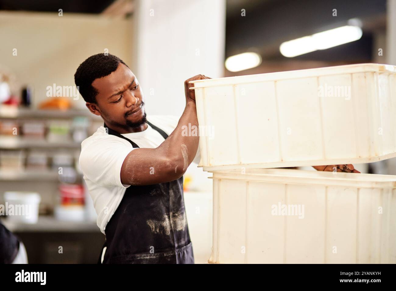 Black man, bakery and bucket with dispenser for mass production, stock ...