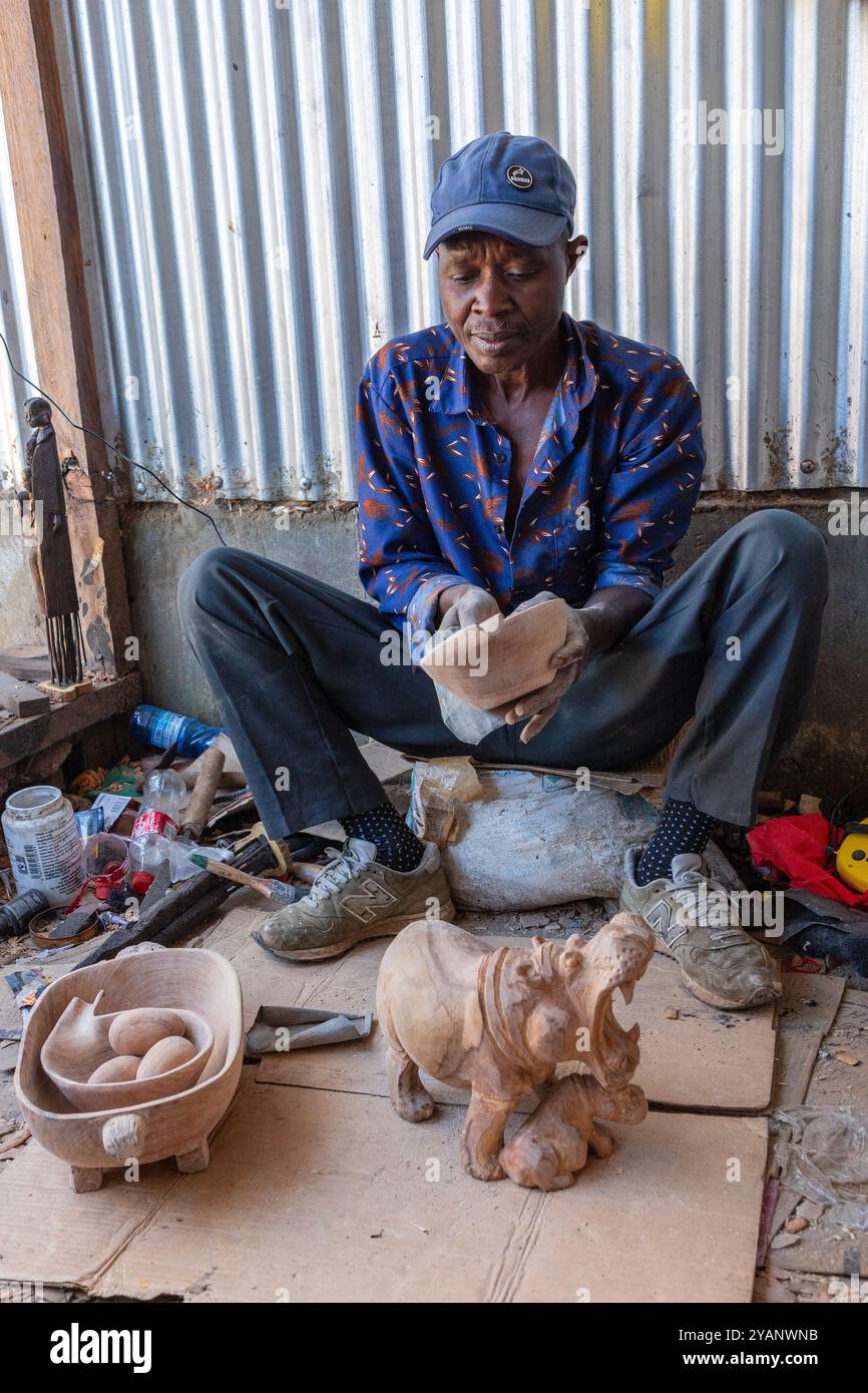 Man carving fruit bowls from mango wood using hand tools to sell as ...