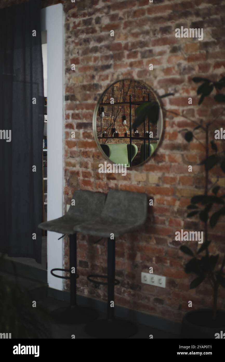 trendy loft interior with cozy armchairs next to a brick wall with ...