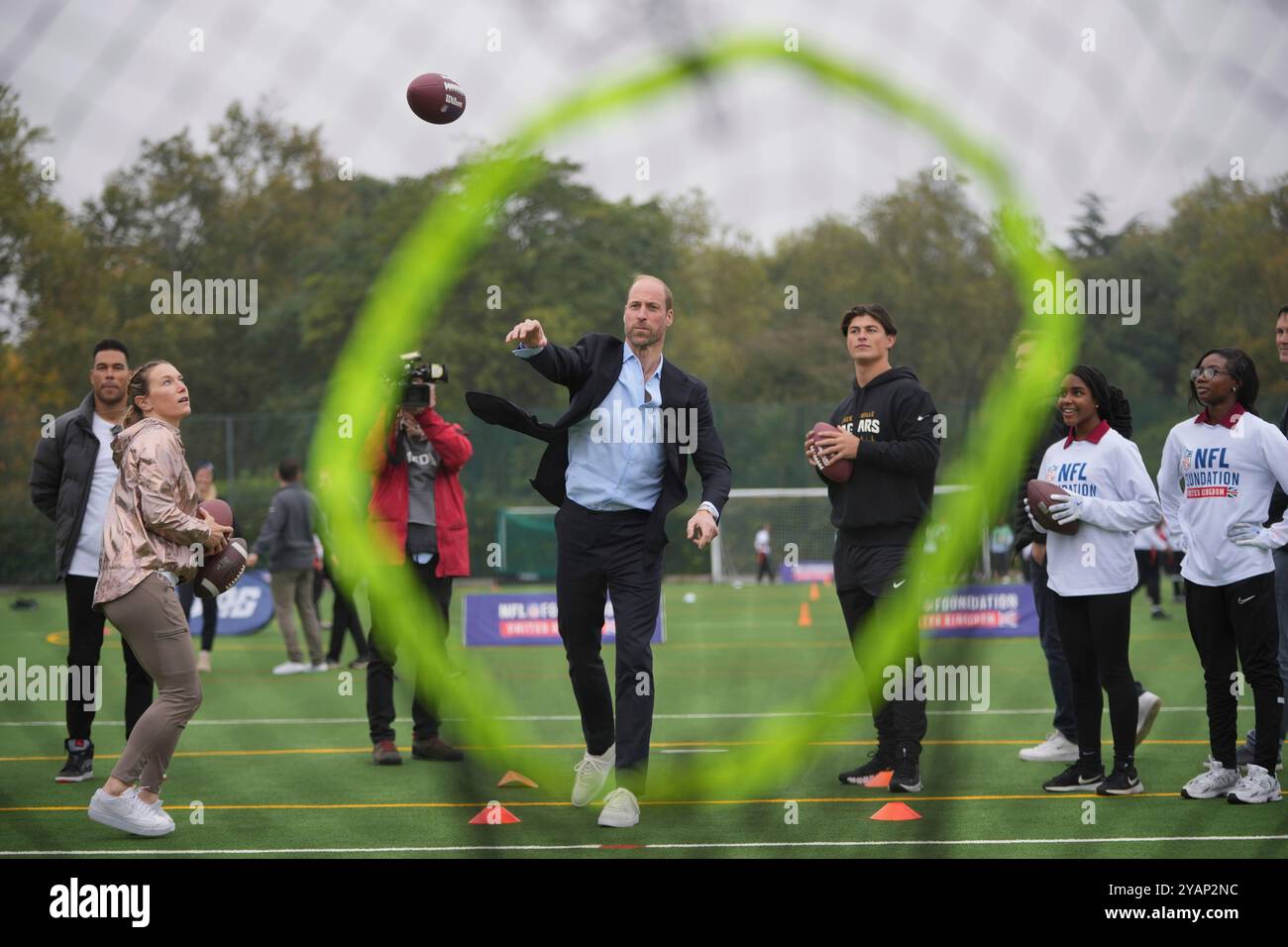 Britain's Prince William throws a football at a target, watched by ...