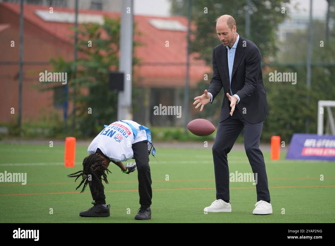 Britain's Prince William catches the football as he attends a NFL ...