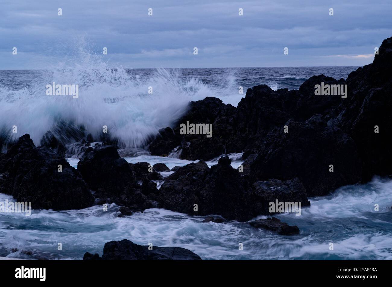 Powerful waves crash over dark volcanic rocks at Porto Moniz natural ...