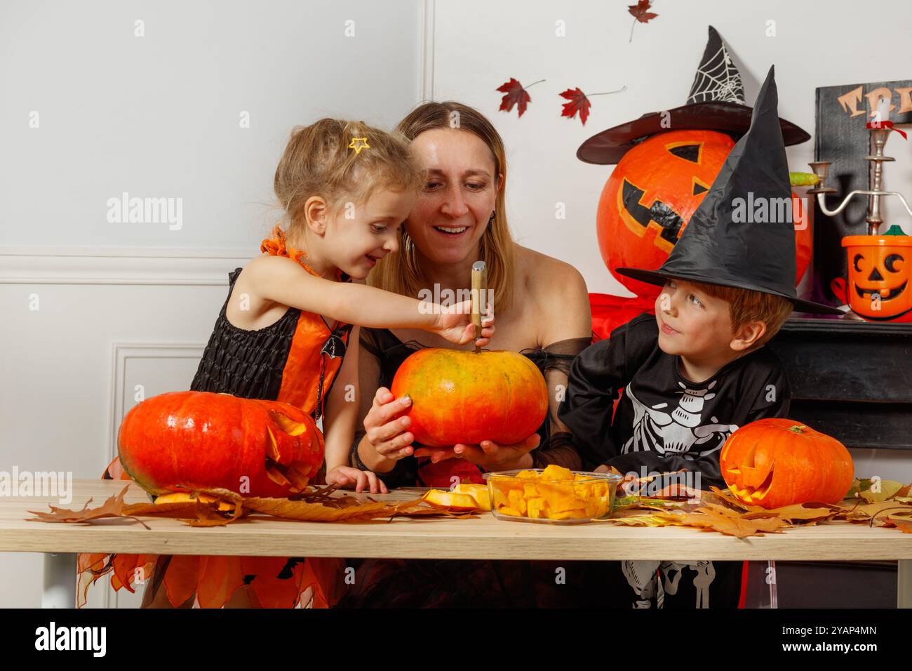 Halloween fun: Family carves pumpkins with joy and creativity Stock ...