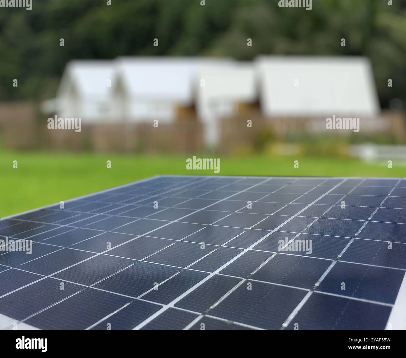 Solar panels set against a backdrop of resident, trees and a vibrant ...