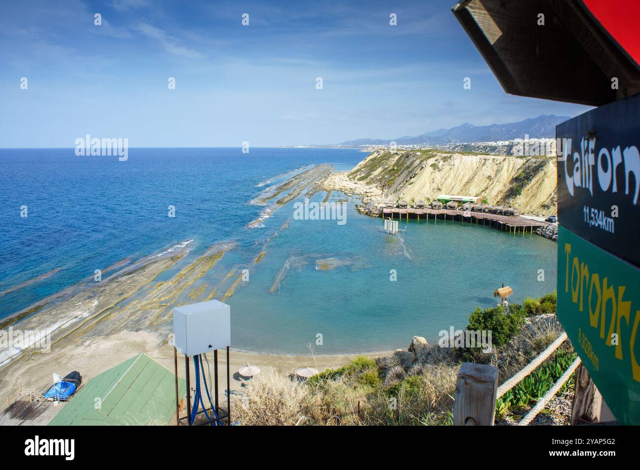 Breathtaking cliffs frame a tranquil bay where gentle waves lap at the ...