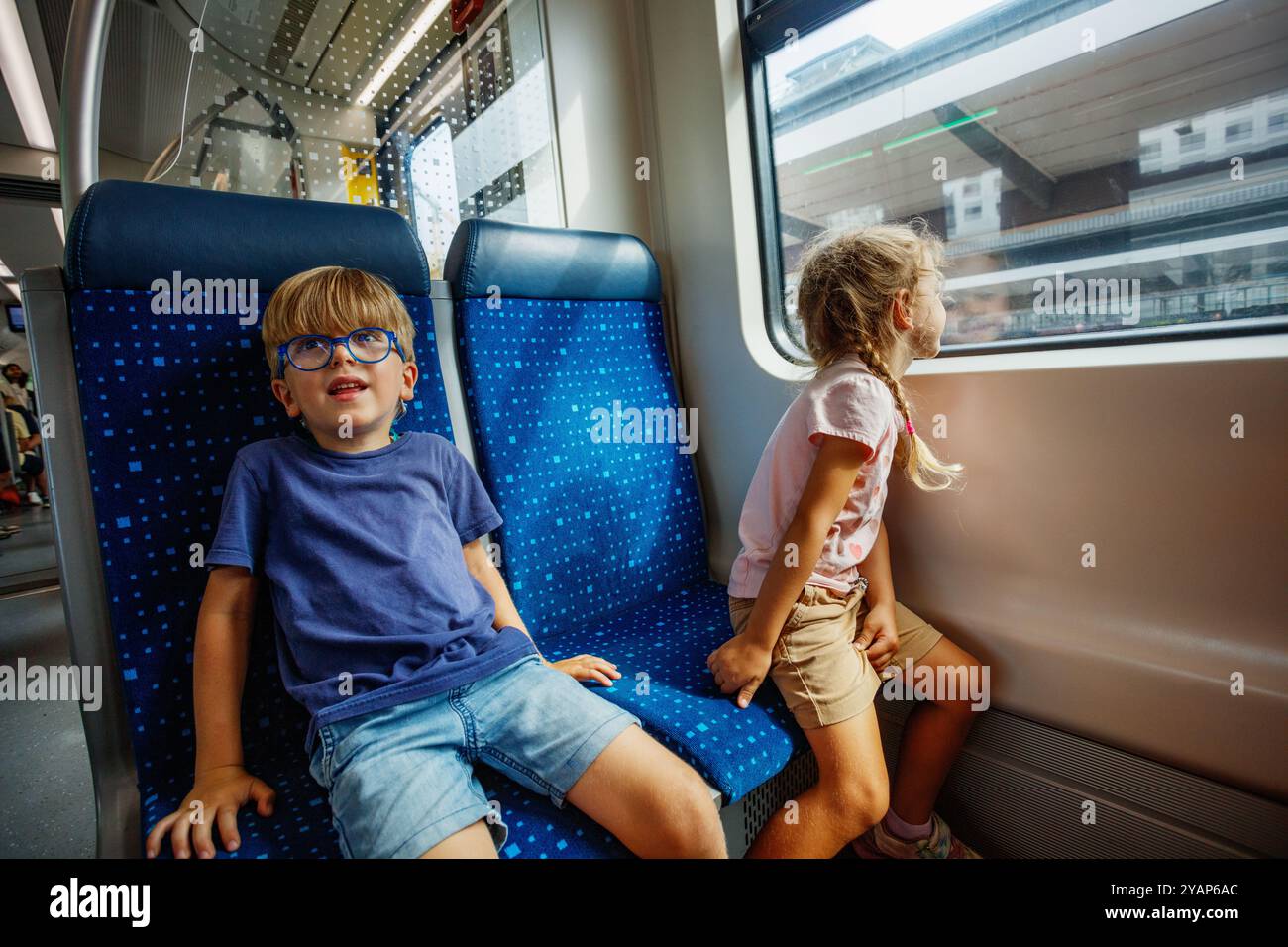 Children riding a train, girl looking out the window, boy seated Stock ...