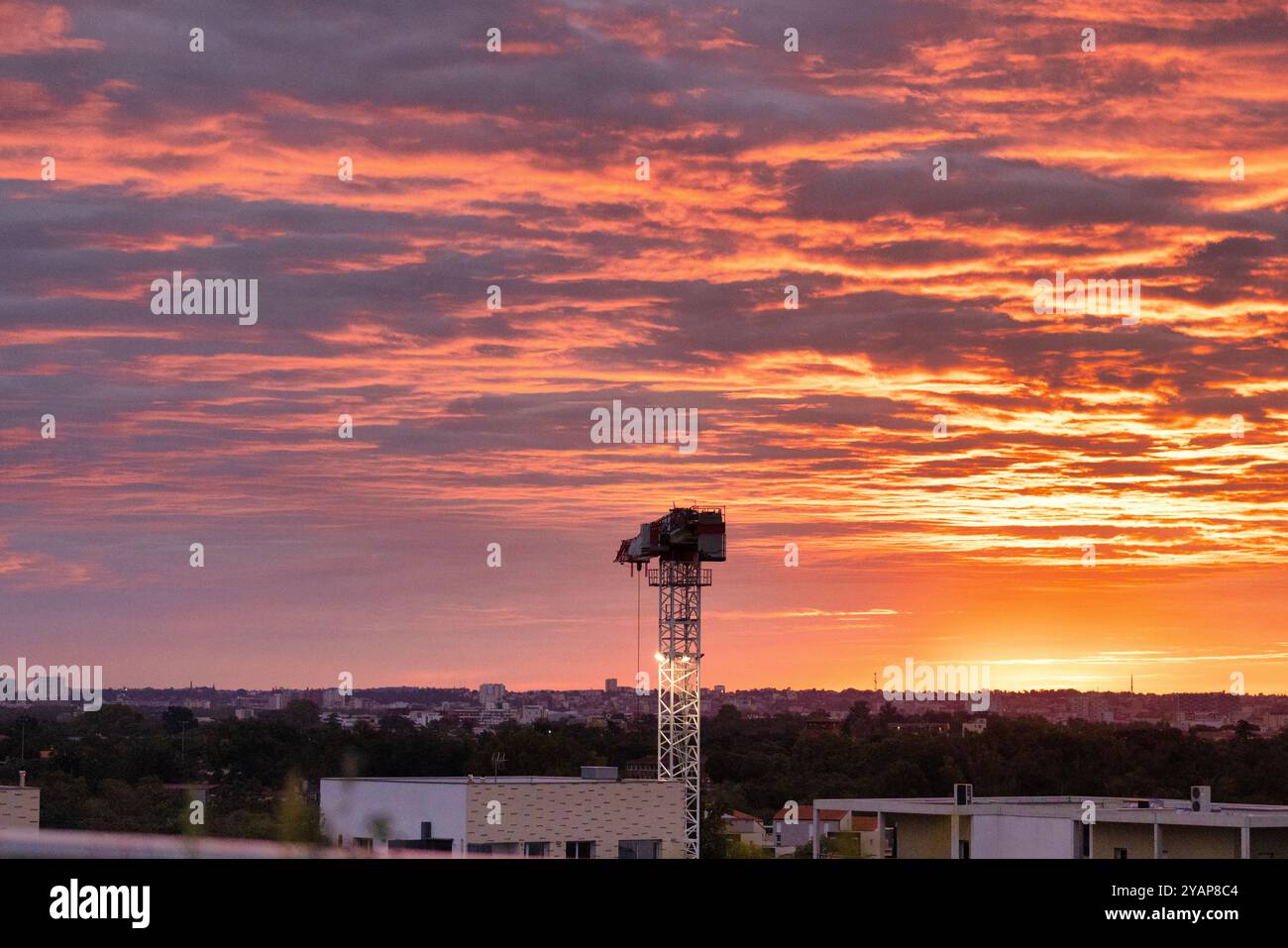 A stunning sunset casts a vivid glow over the urban landscape with a ...