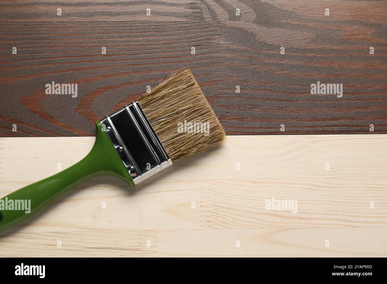 Applying walnut wood stain. Brush on wooden surface, top view. Space ...