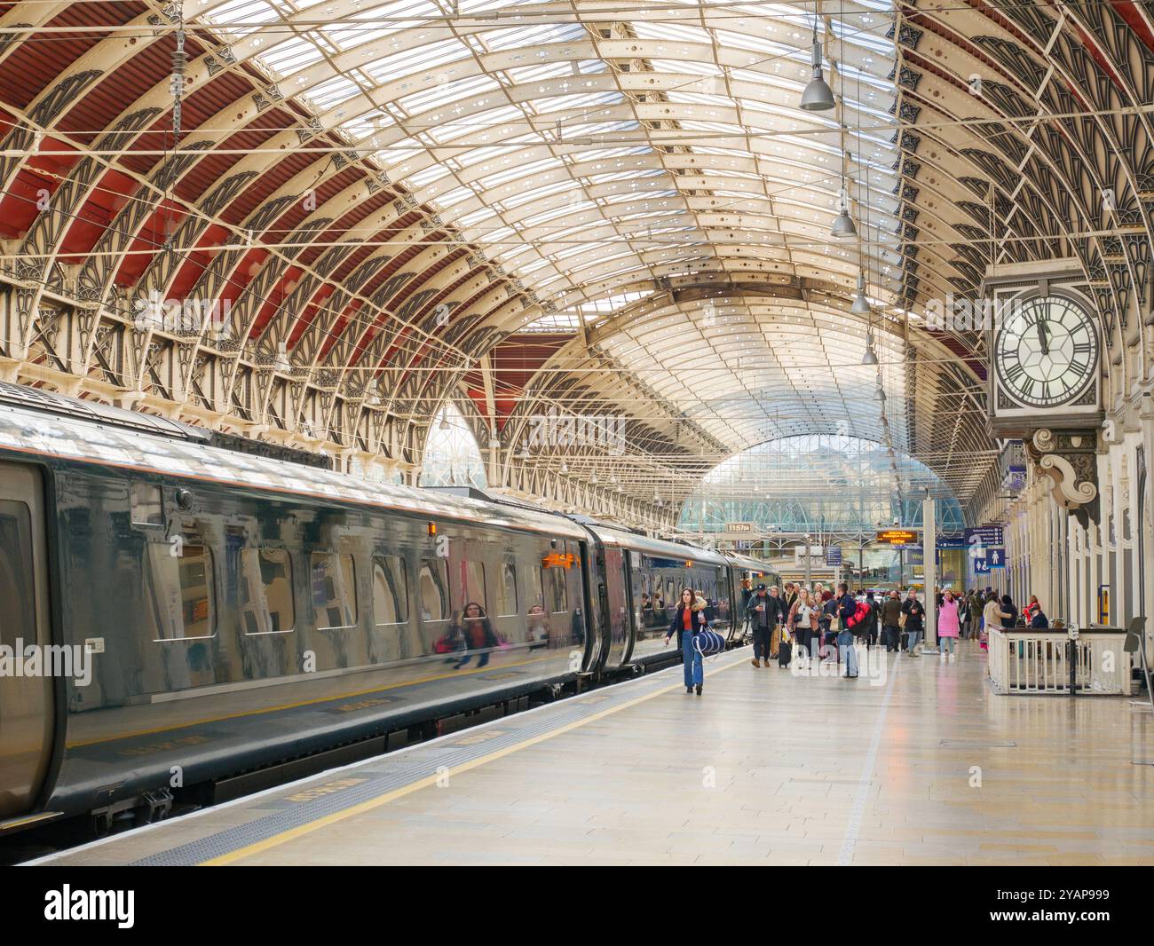 People boarding a GWR train on the platform at Paddington Station ...