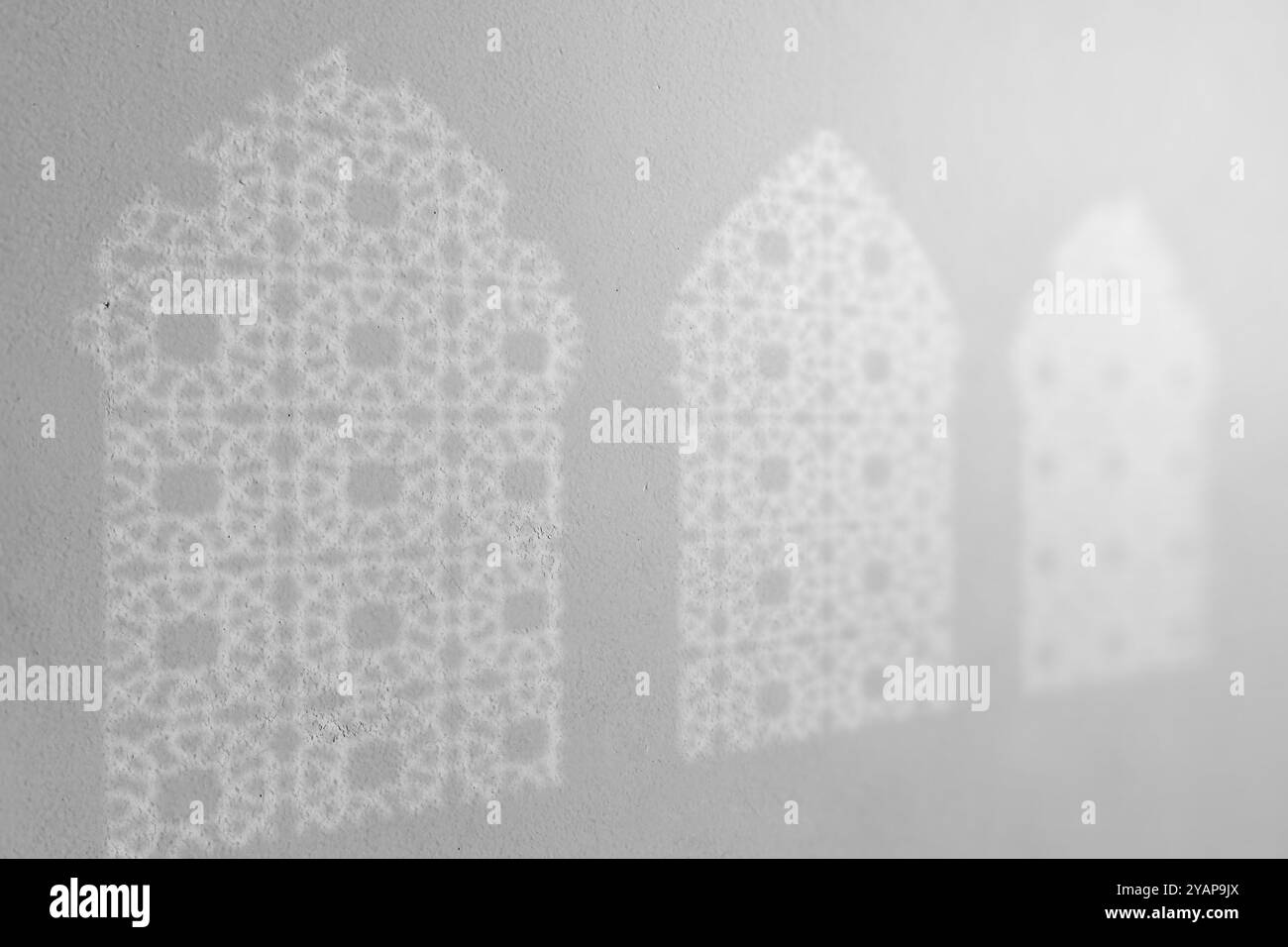 White shadow of three arched mosque windows on the wall. Islamic ...